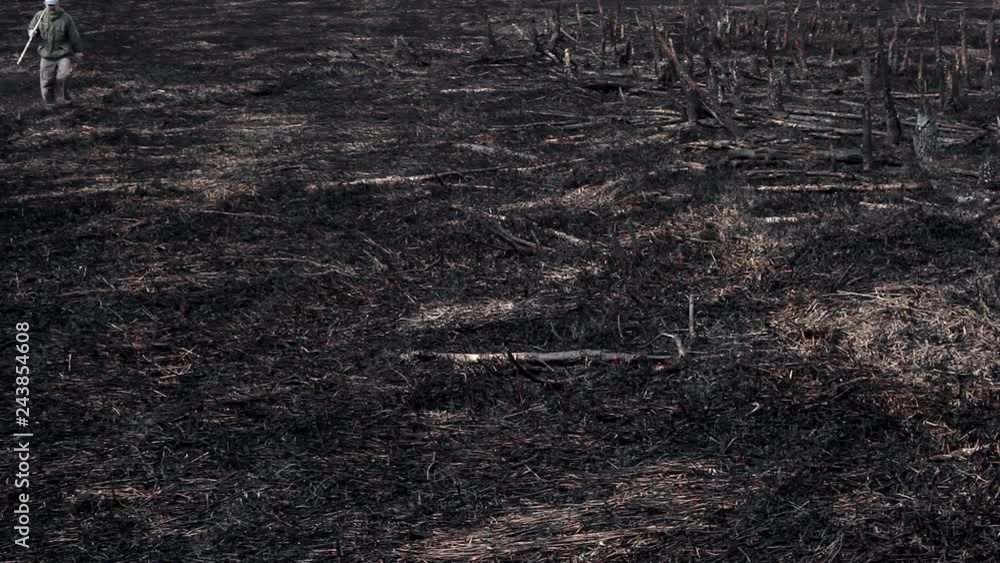 A sip of water in the middle of burnt land/Natural disaster. A man with ...