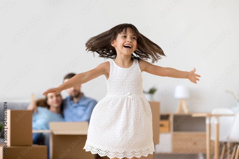 Excited cute child feel carefree having fun relocating into new home ...