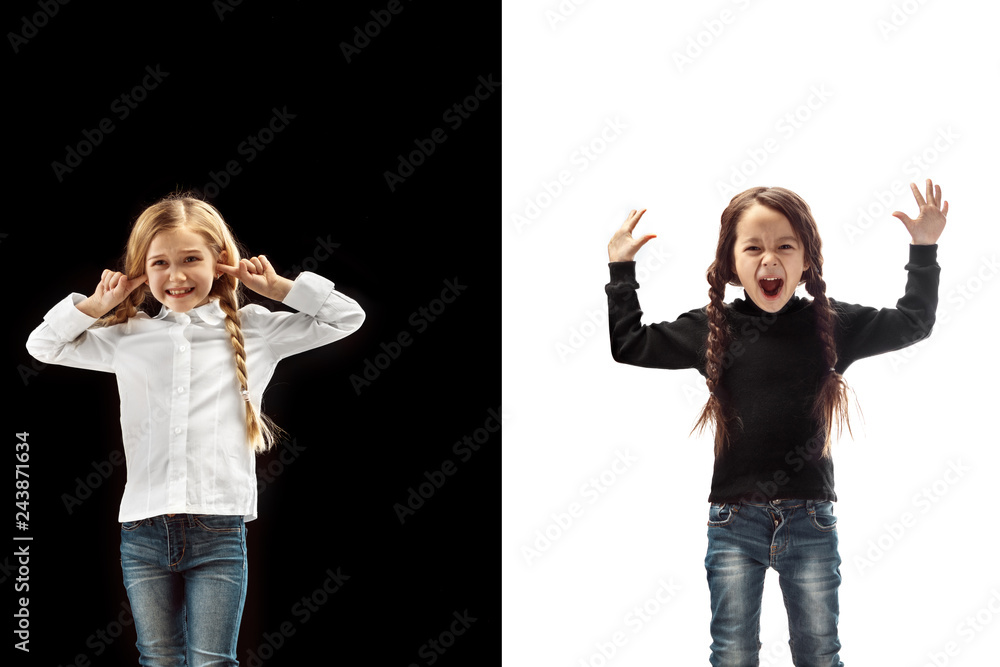 The portrait of two happy screaming girls on a white and black studio ...