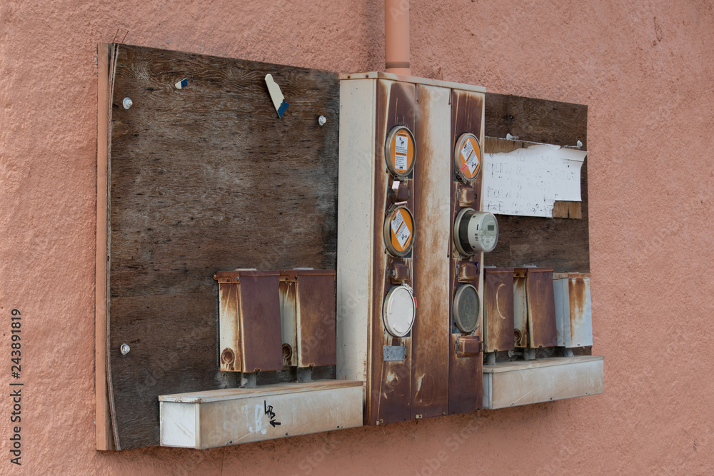 Old electrical panel with meters and breakers mounted on a stucco wall ...