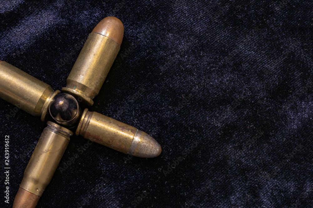 Pistol bullets gathered together in the shape of a cross. War concept ...