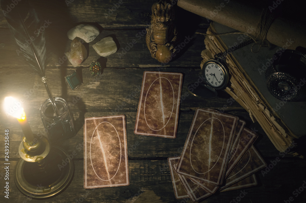 Tarot cards on fortune teller table in the lights of burning candle ...