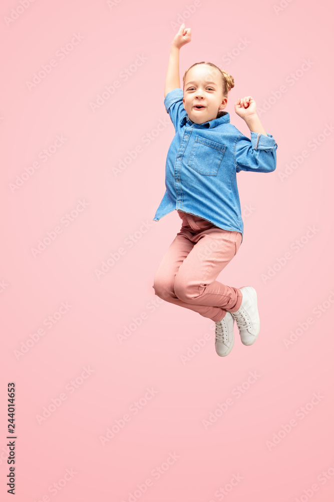 Young happy caucasian teen girl jumping in the air, isolated on pink ...