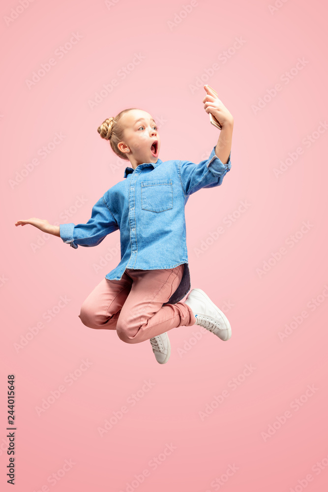 Young happy surprised caucasian teen girl jumping with mobile phone in ...