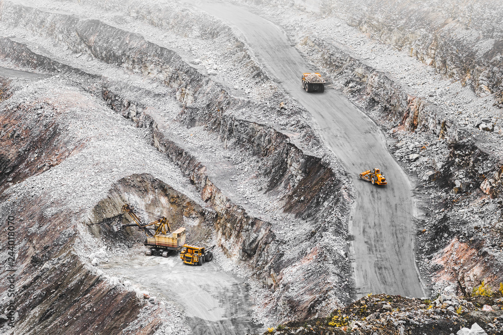 Large mining trucks, excavator and bulldozer in a quarry. Iron ore ...