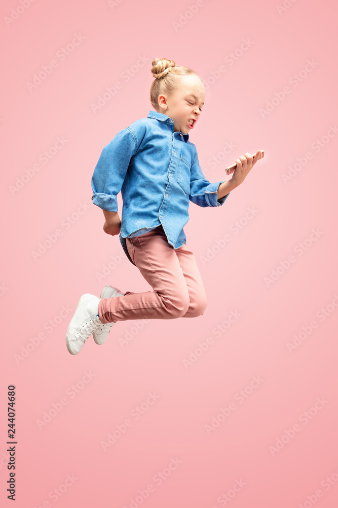 Young happy surprised caucasian teen girl jumping with mobile phone in ...