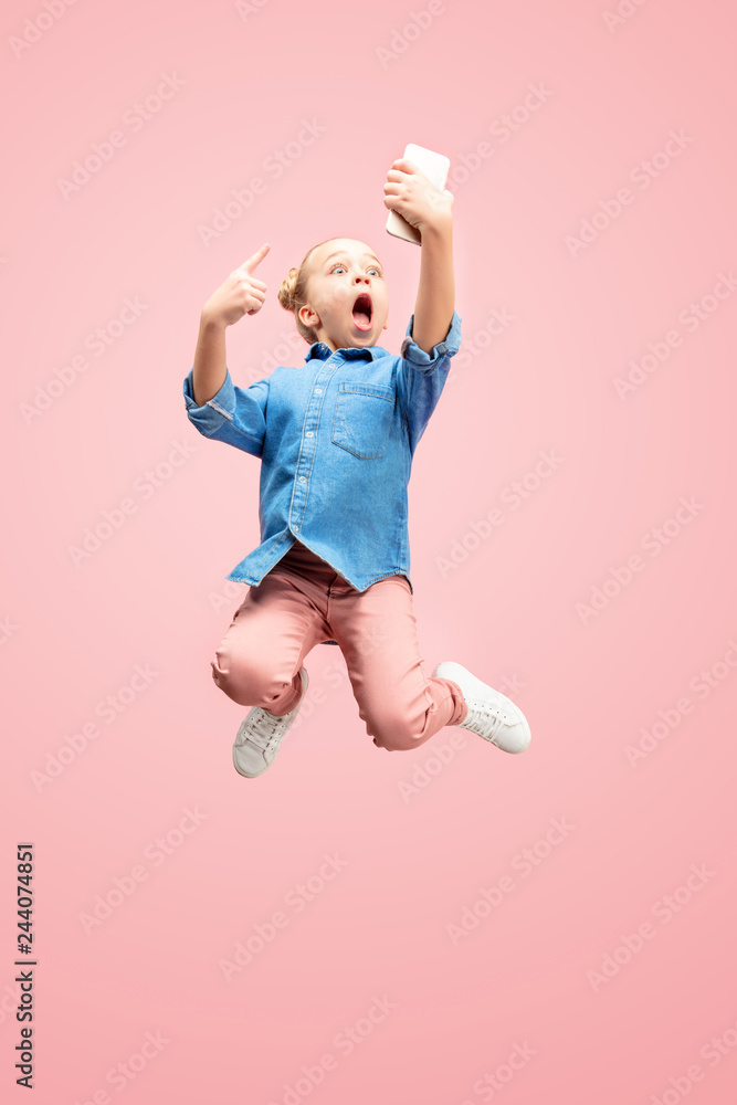 Young happy surprised caucasian teen girl jumping with mobile phone in ...