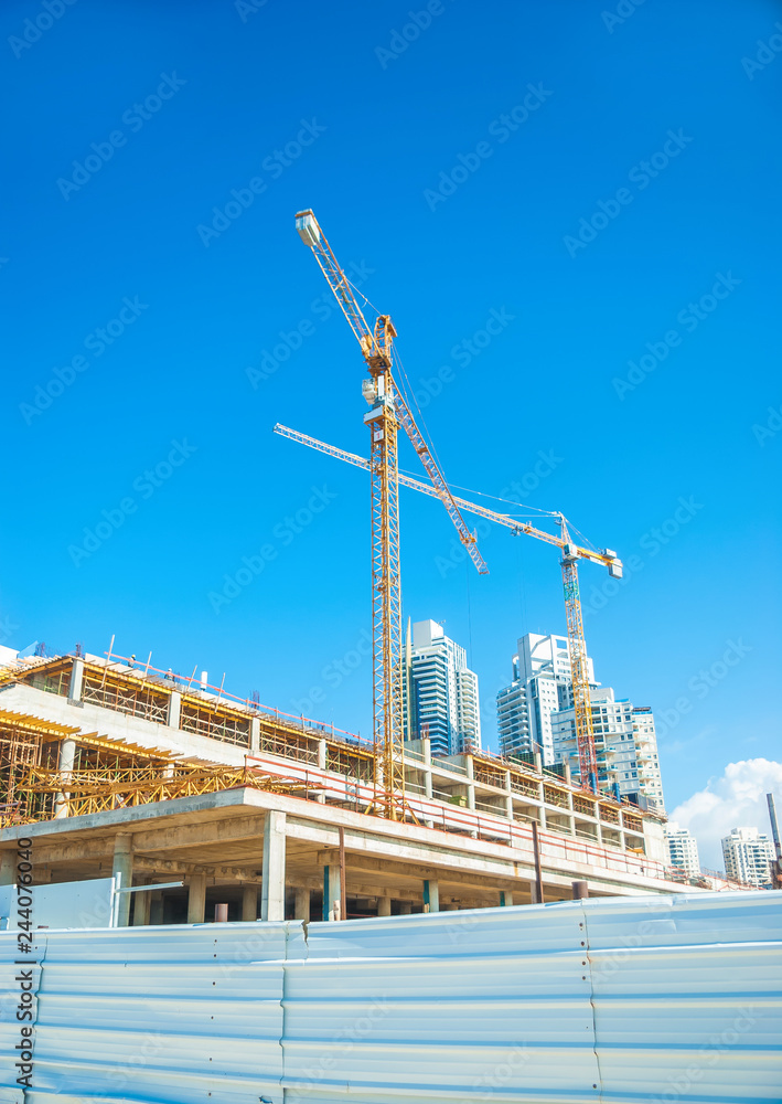 Foto de Construction site. Big industrial tower cranes with unfinished ...