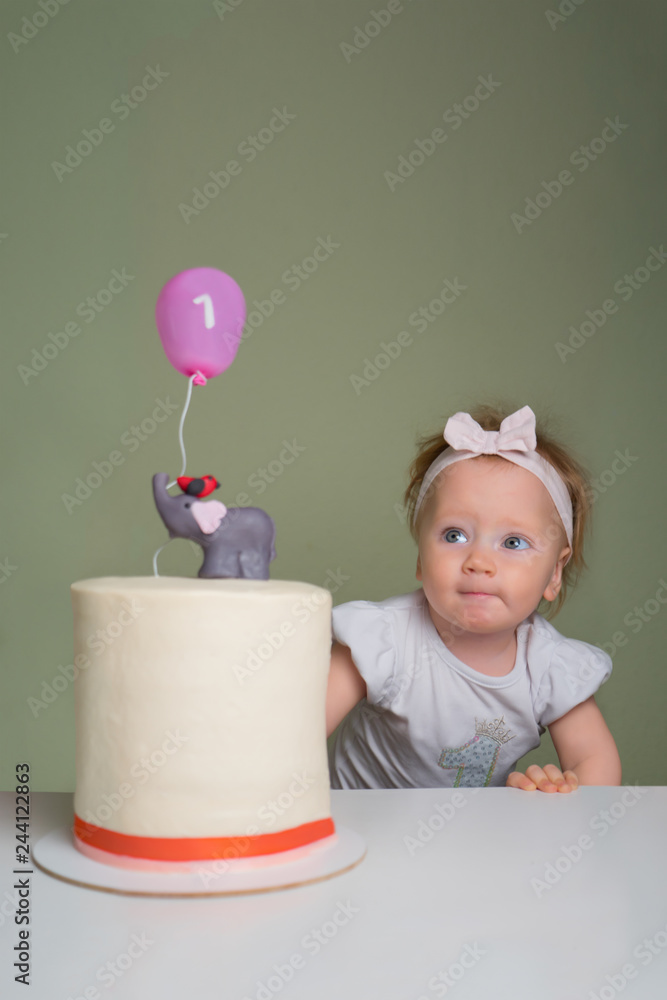 Girl trying to touch birthday cake with her finger. Positive emotions ...