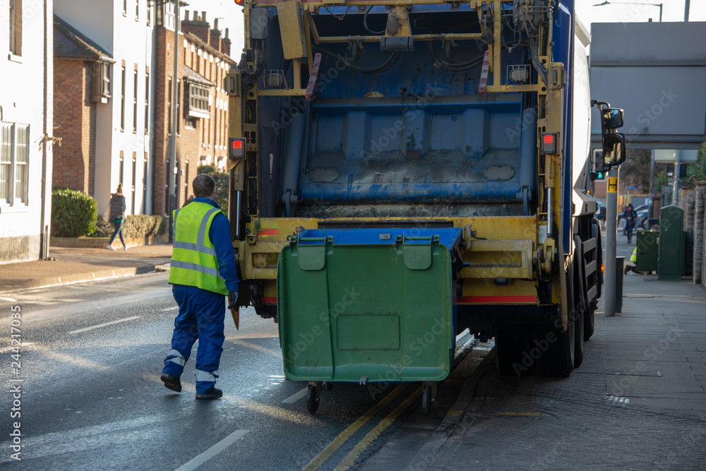 bin lorry or waster truck collects refuse from a green dumpster with ...