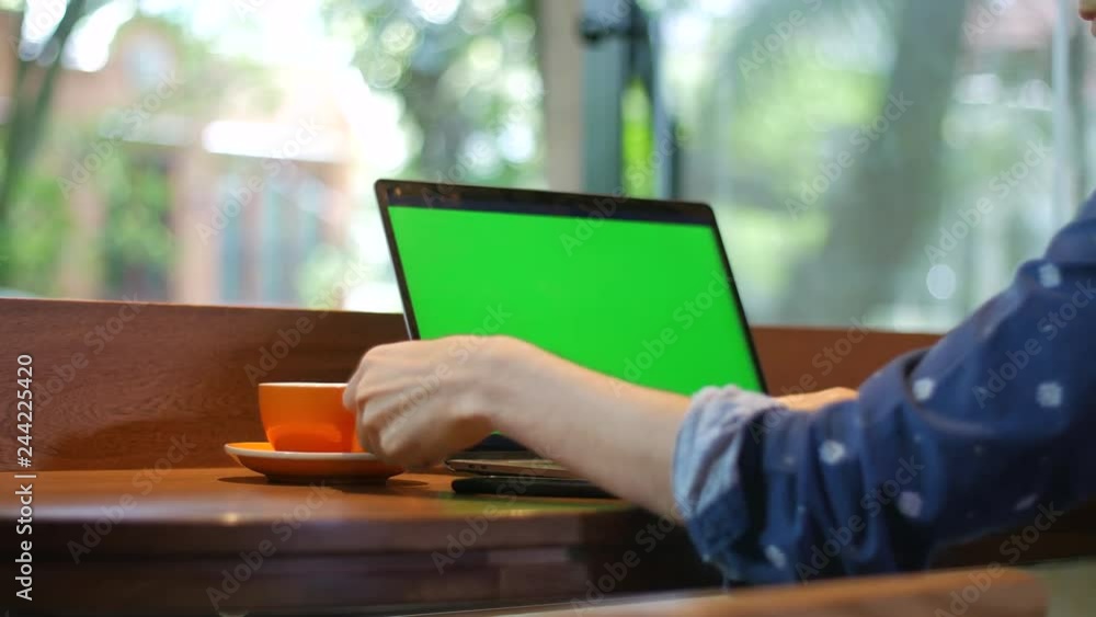 Close-up of laptop computer with chroma key greenscreen, with hands of ...
