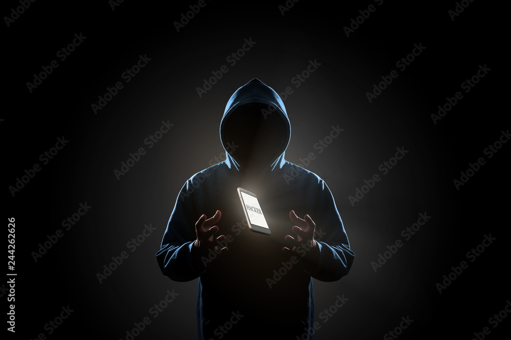 White smartphone with text "HACKER" on screen floating above of hacker ...