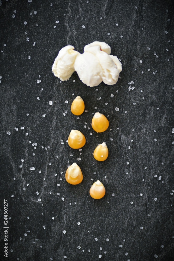 Concept with popcorn and corn - popcorn corn rains from a poped corn ...