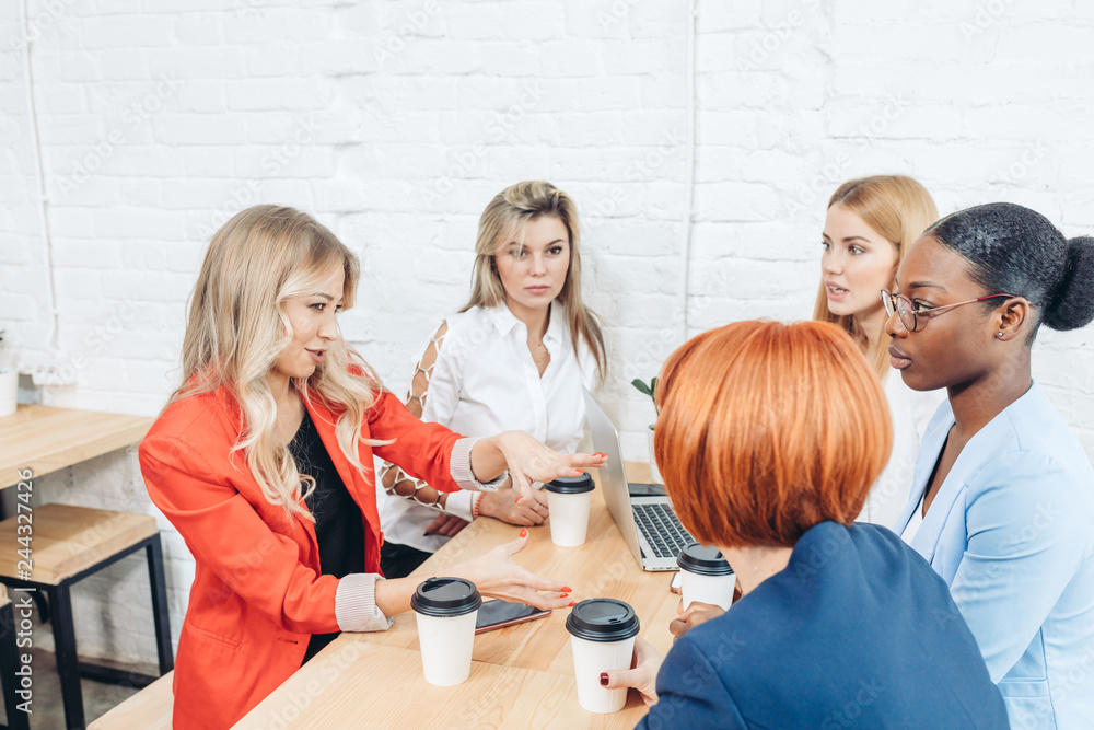 Team work process. Multiracial group of young women collaborating in ...