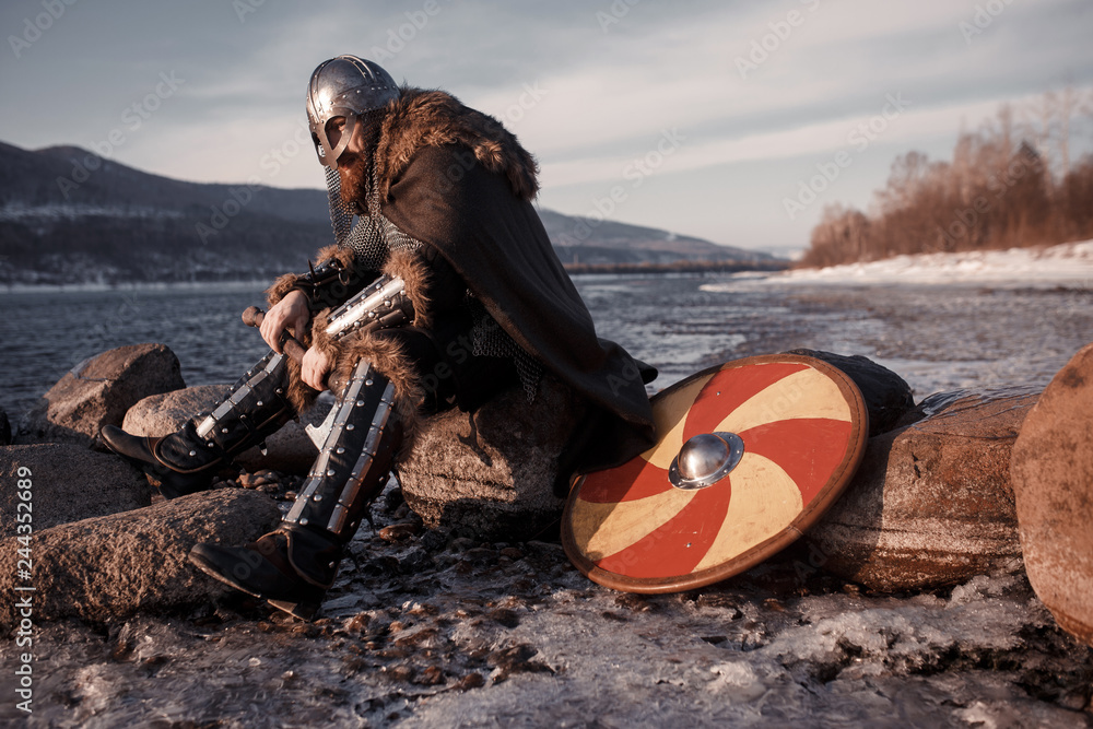 Medieval Scandinavian warrior Viking in full outfit on shore of winter ...