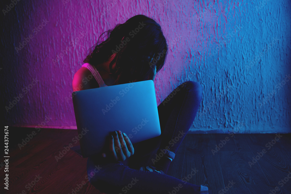 scared and sad female teenager with computer laptop suffering ...