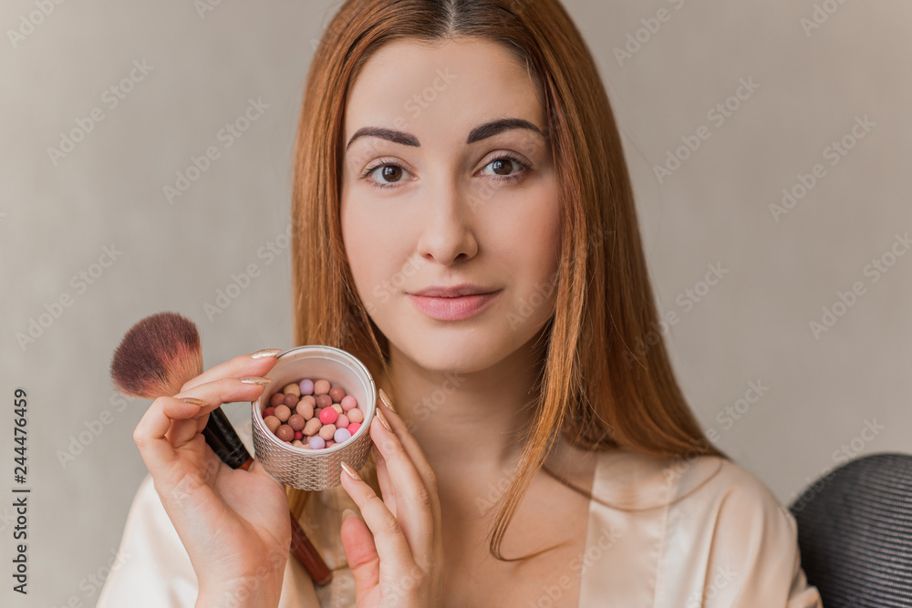 Face powder. Closeup Of Beautiful Female Model Applying powder on a ...