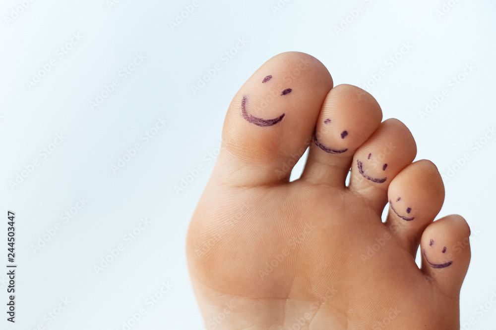 Female toes with painted smileys. Stock Photo | Adobe Stock