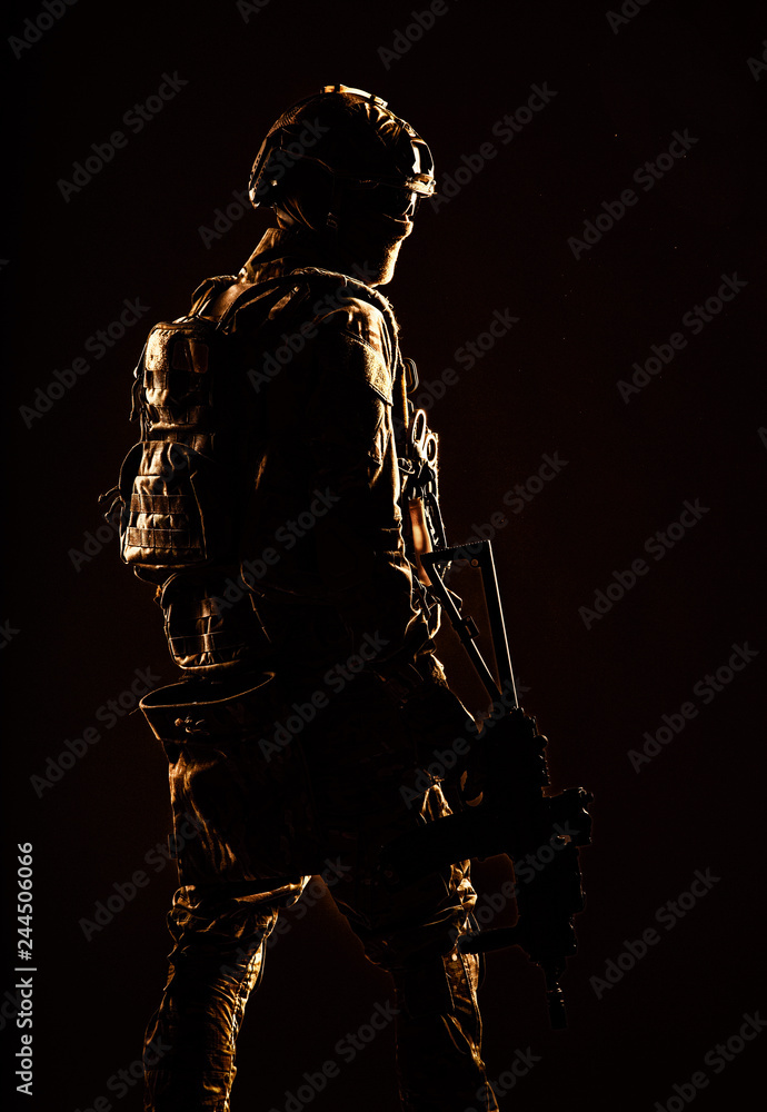 Low key studio shoot of army special forces soldier, commando fighter ...