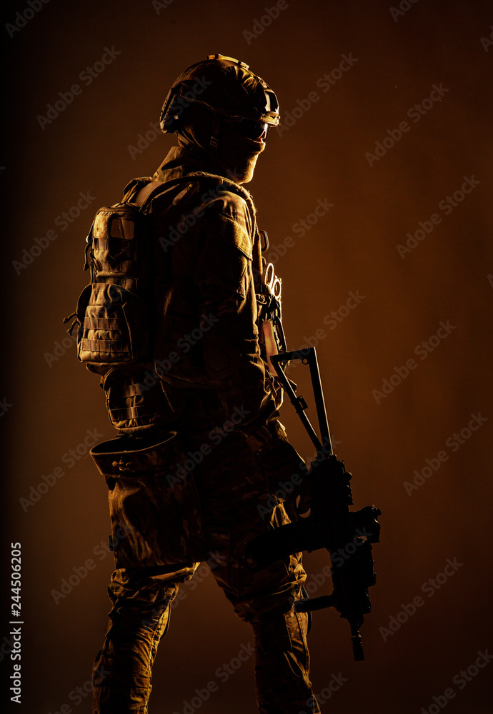 Low key studio shoot of army special forces soldier, commando fighter ...