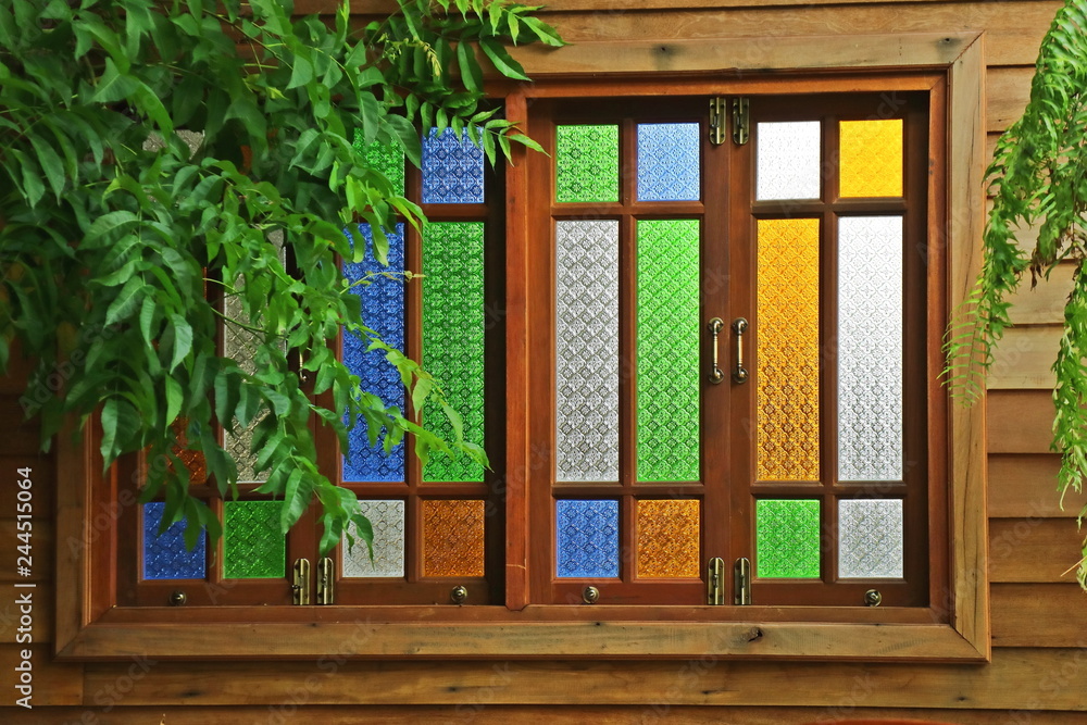 Stained glass window, thai style wooden window with green leaves ...