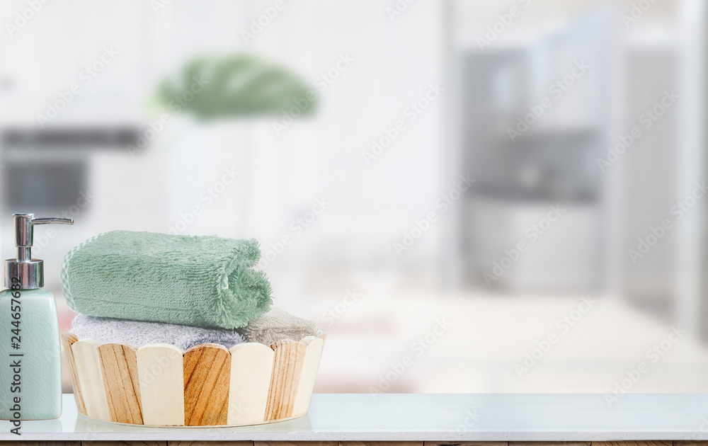 Mockup wooden bath bucket with towels on white table with blured white ...