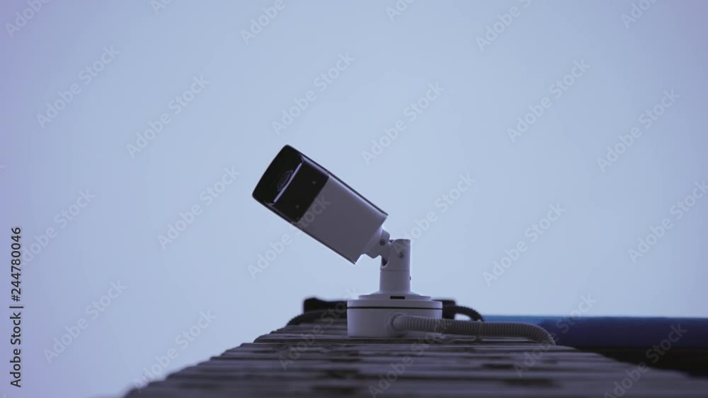 Surveillance camera on the street. Watching people. Camera on the wall ...