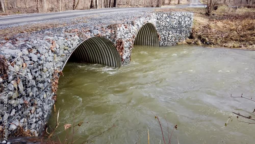 Muddy water flowing through two corrugated culverts. Stock 비디오 | Adobe ...