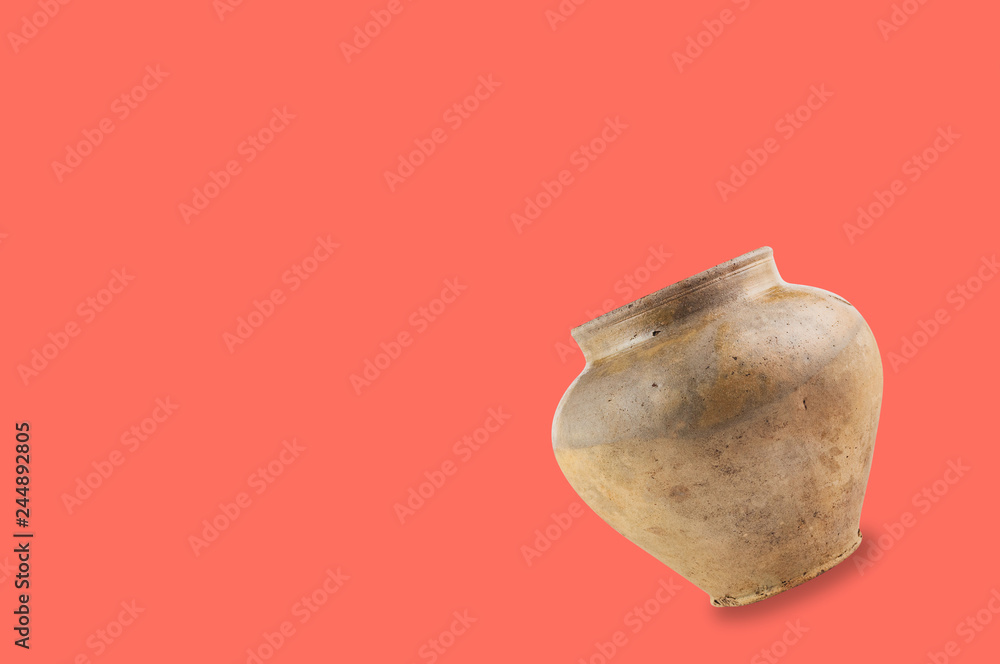 One old antique worn and dirty vase on coral color table with copy ...