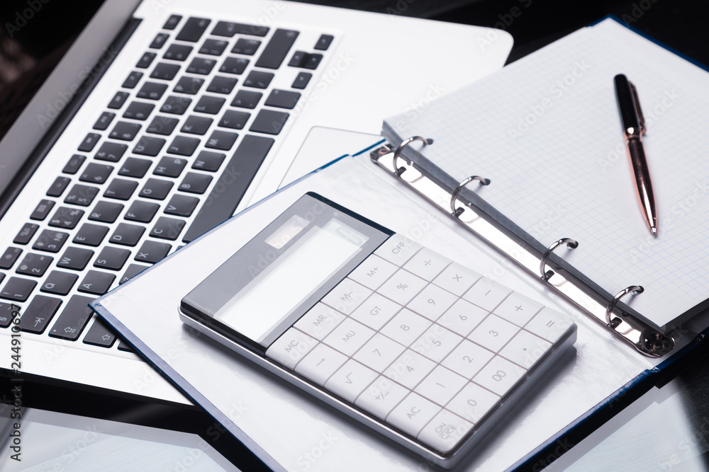 Modern calculator is on a laptop and on an open notebook Stock Photo ...