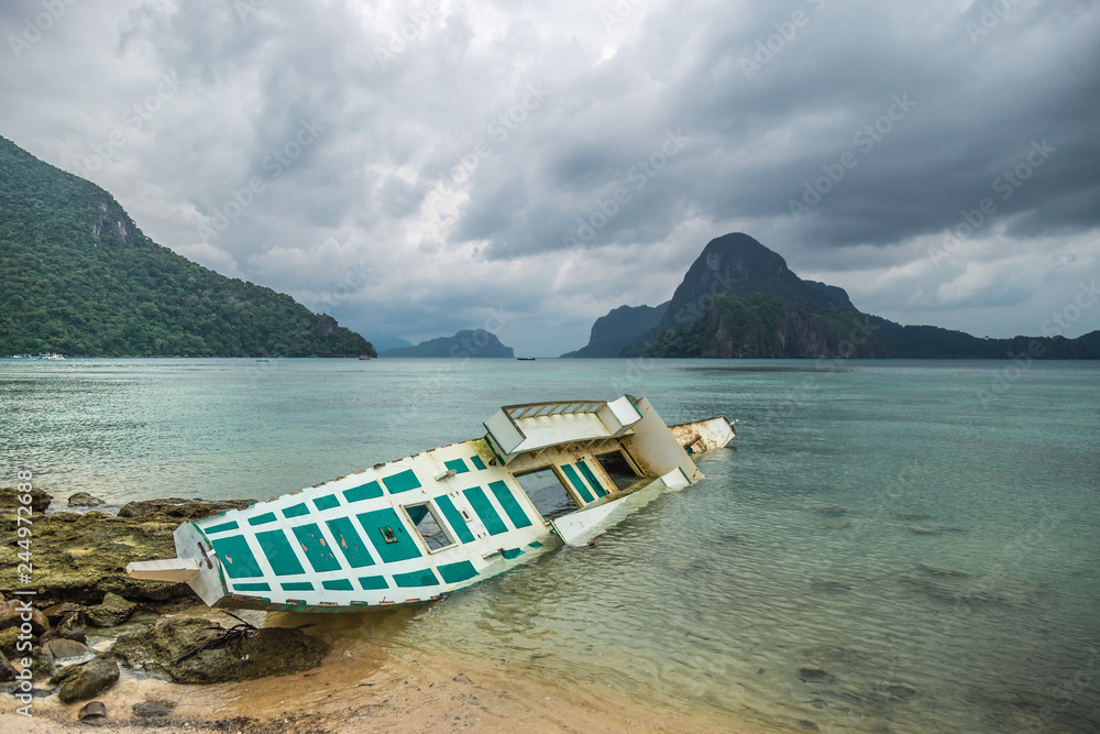 Broken fishing boat stranded after typhoon in rainy weather in El Nido ...