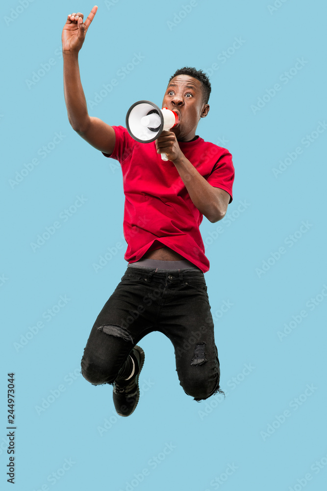 Soccer fan jumping on orange background. The young african man as ...