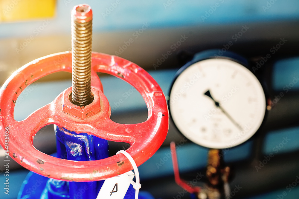 Red gas valve and pressure gauge with an arrow on the limit. Background ...