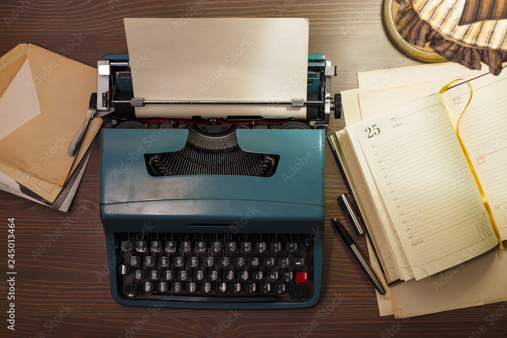 Top view of vintage typewriter with blank paper sheet, documents, diary ...