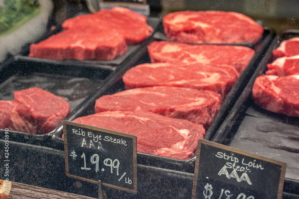Fresh cuts of steak on display at a butcher Stock Photo | Adobe Stock