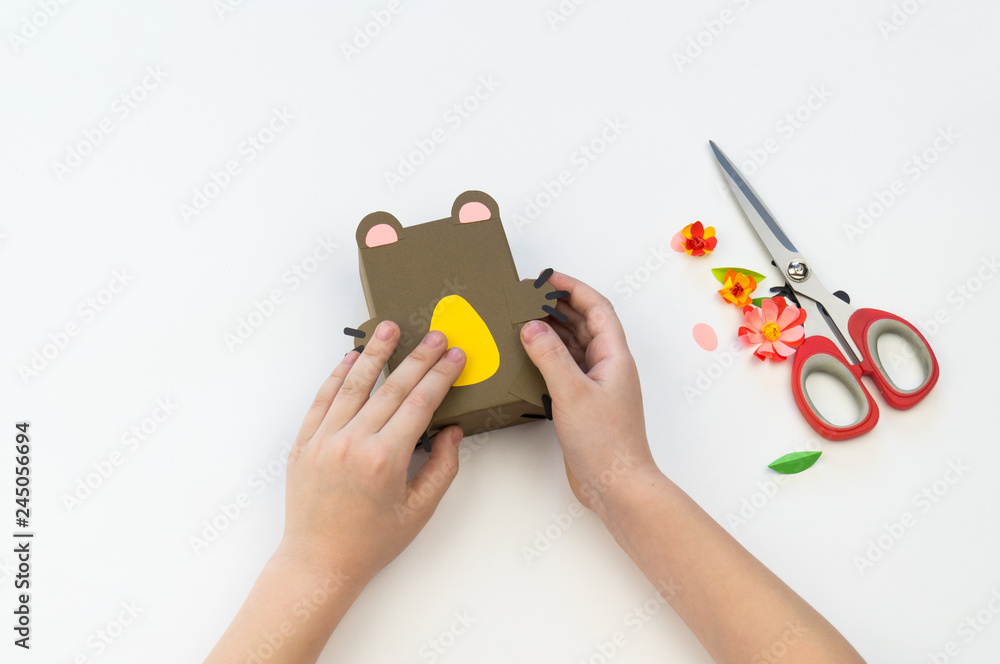 Child making gift a bear box. Teddy bear out of paper craft. Packaging ...