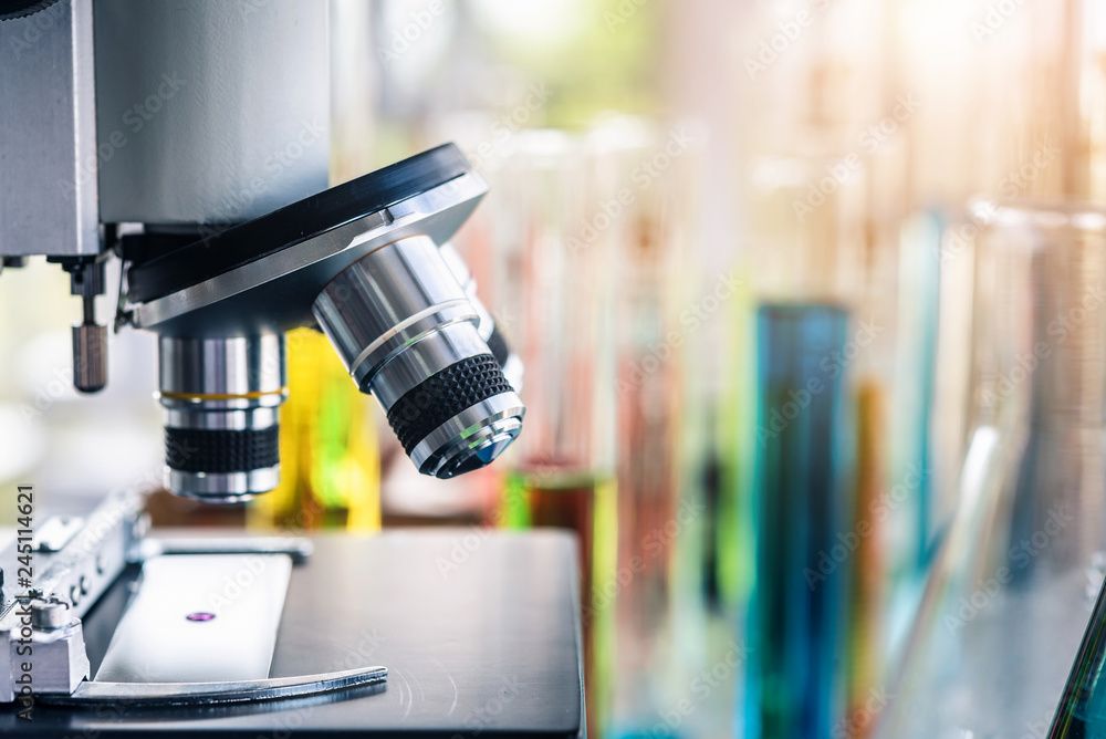 Microscope in microbiology lab with laboratory glassware background for ...