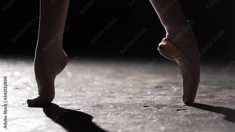 Female foot standing in spotlight on black background in studio. One ...