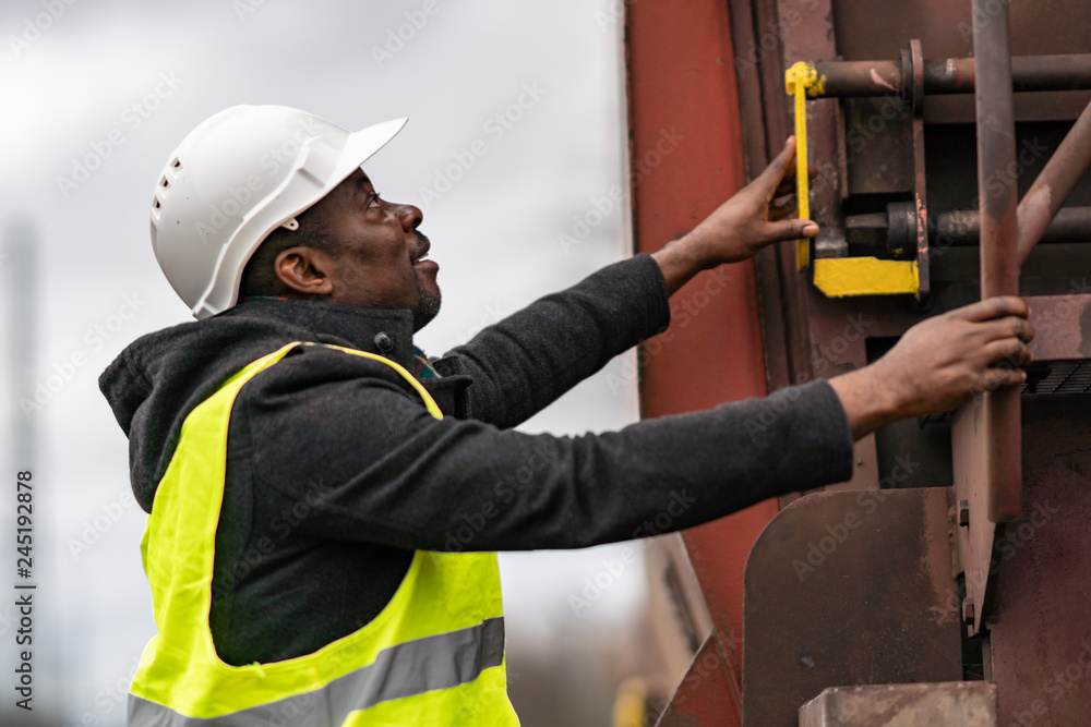 African American railroad engineer wearing safety equipment (helmet and ...