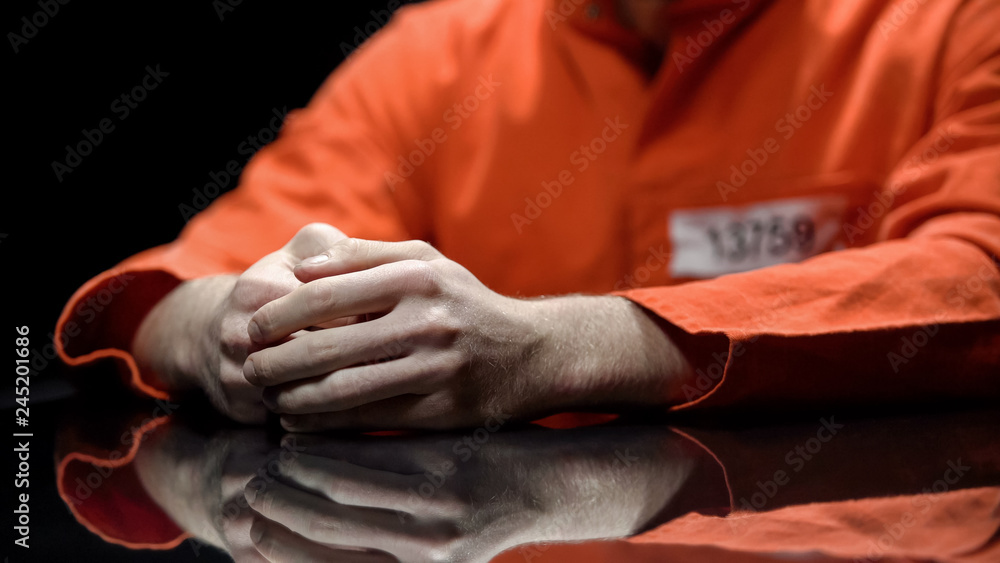 Hand of male prisoner, inmate giving evidence in detention room ...