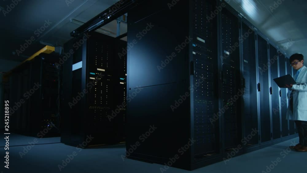 In Data Center: Male and Female IT Specialists Wearing White Coats Work ...