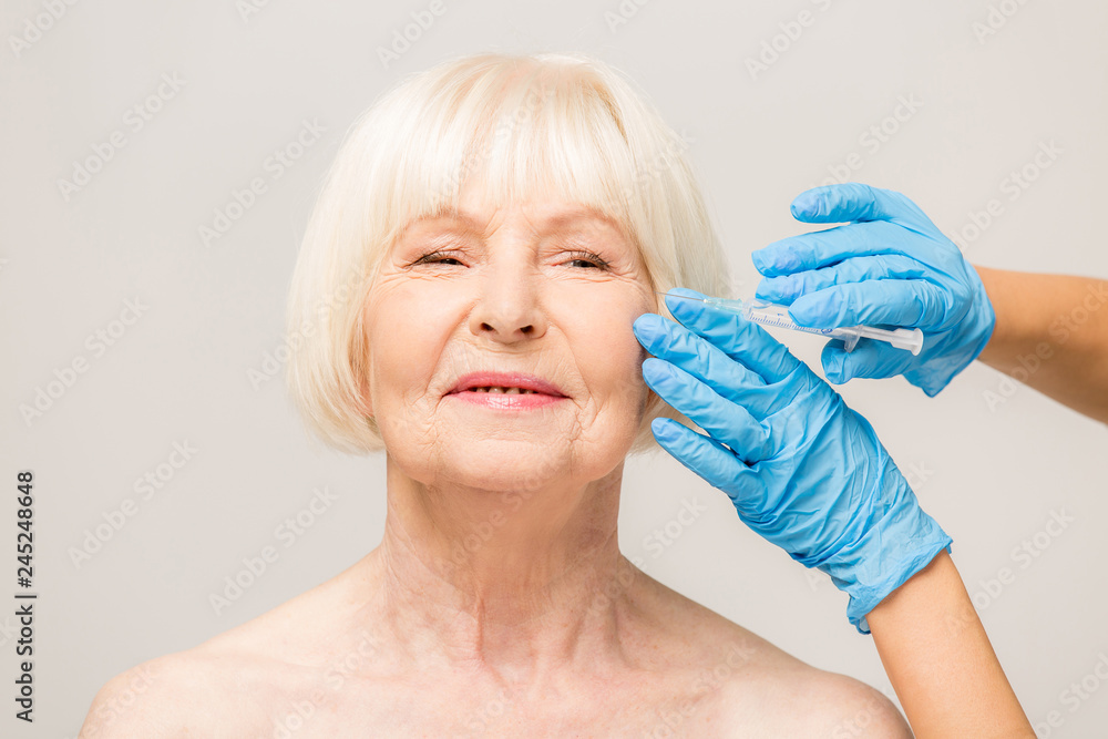 Senior woman getting skin care injection. Aged lady having botox ...