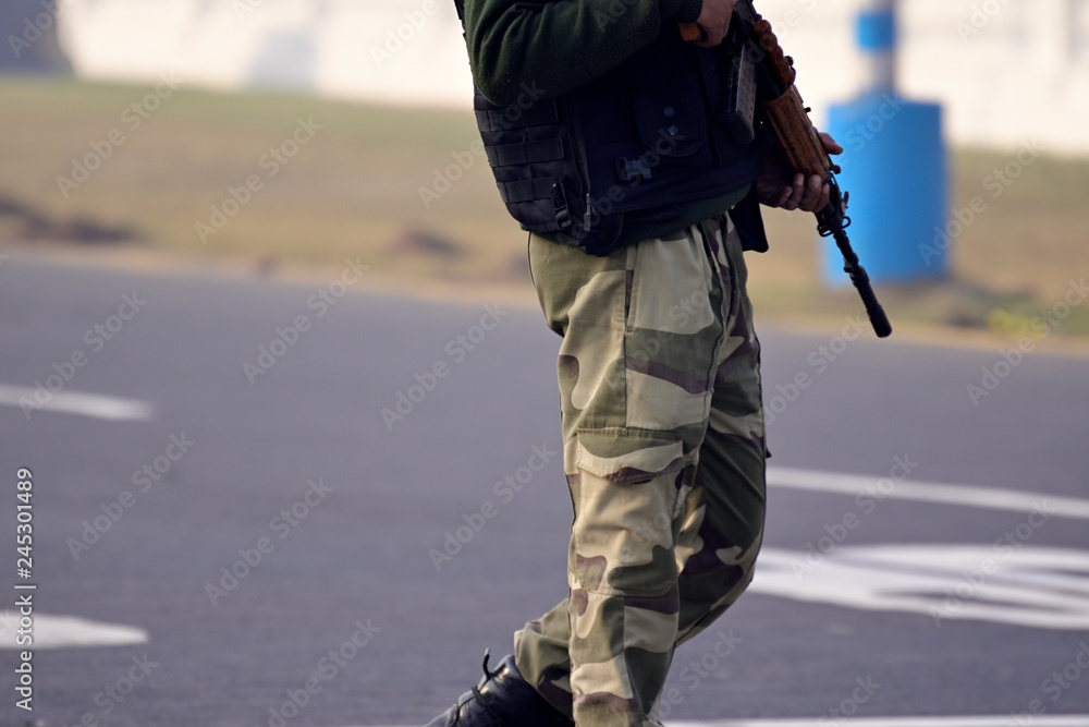 Security guard with rifle standing on outside to protect the area ...