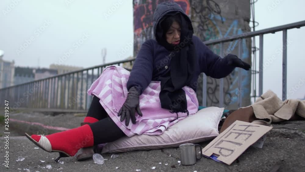 Homeless woman appreciate the shoes worn on a thick red sock and looks ...