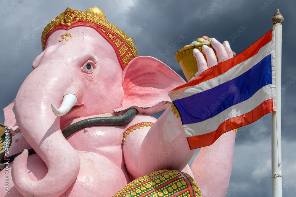 Large statue of elephant with fluttering national flag of Thailand ...