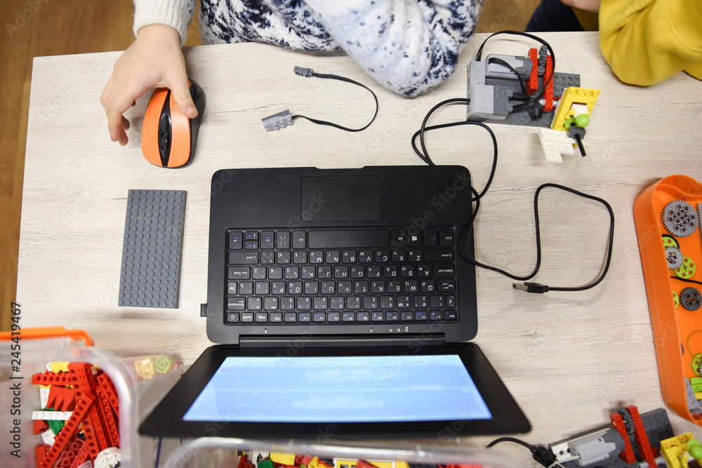 Group of kids building robot constructor from the plastics details ...