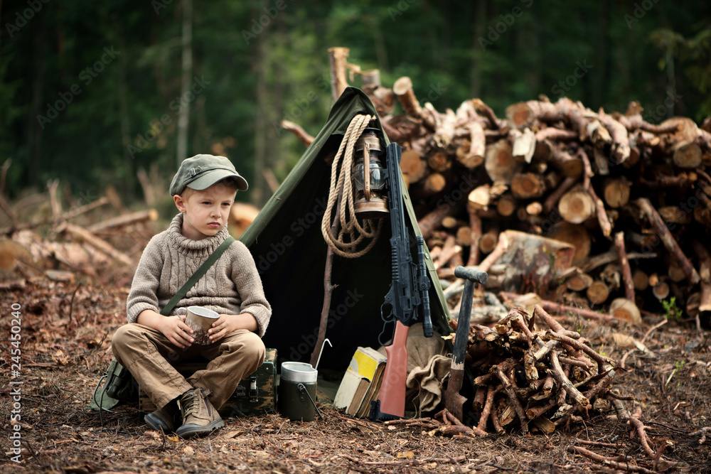 The boy, 5 years old, looks like a trapper, wanderer, lumberjack. Hut ...