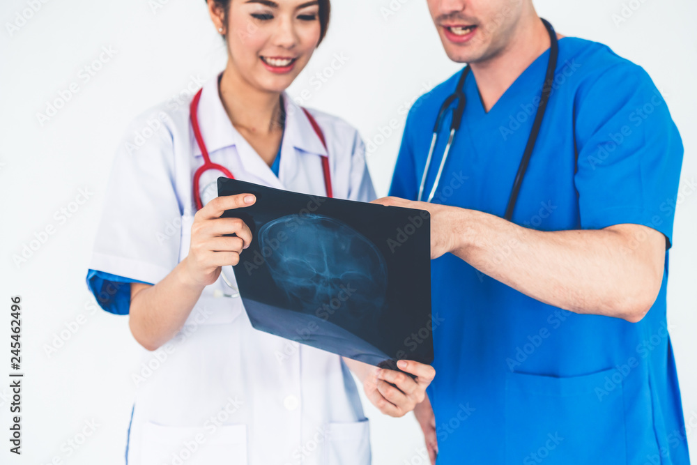 Female doctor looking at x ray film of patient head injury while ...