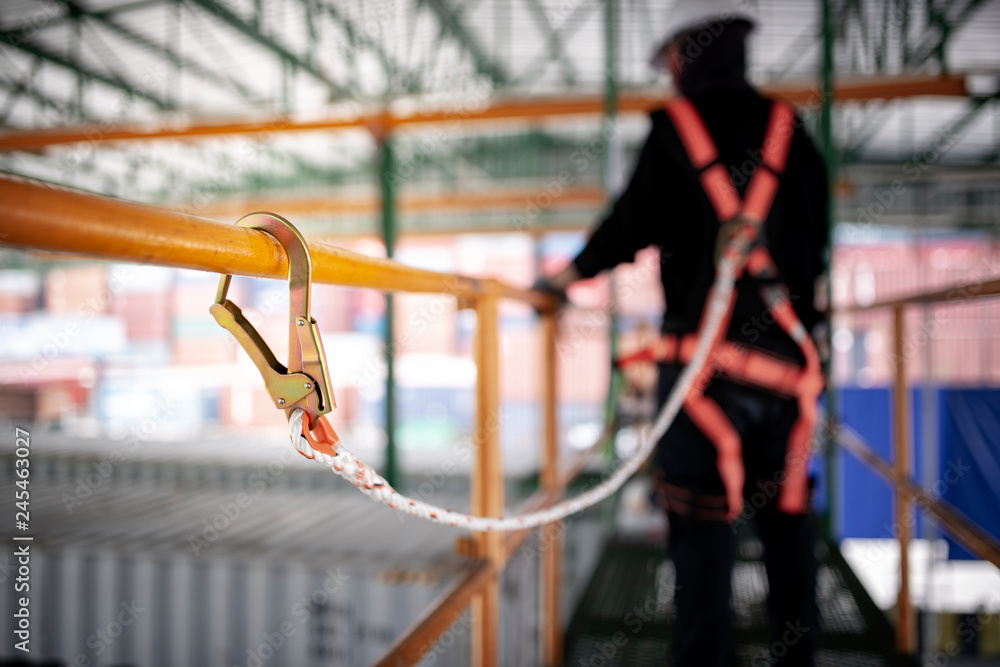 Construction worker wearing safety harness and safety line working on ...