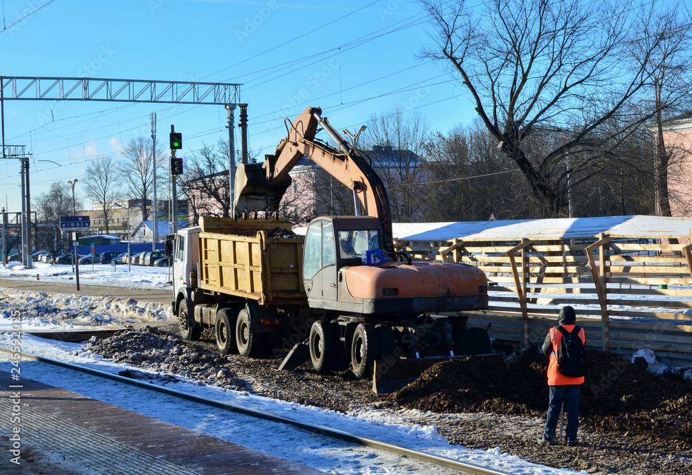 The excavator loads crushed stone in a dump truck body. Construction of ...